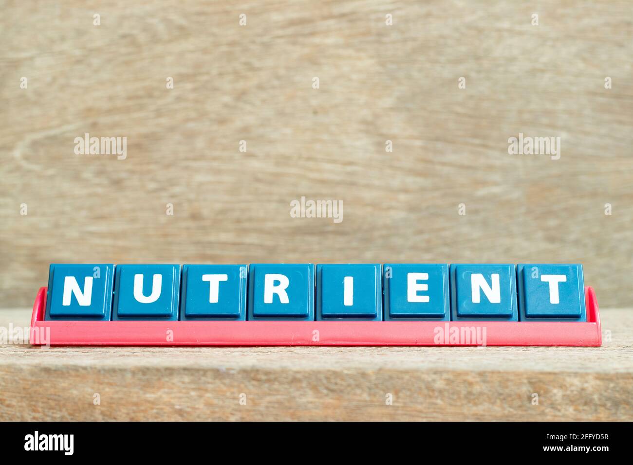 Tile alphabet letter with word nutrient in red color rack on wood ...