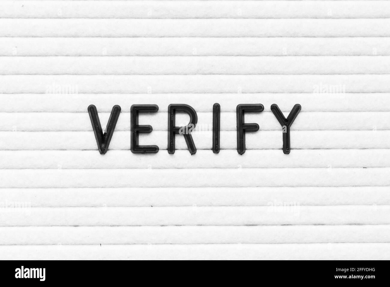 Black color letter in word verify on white felt board background Stock ...