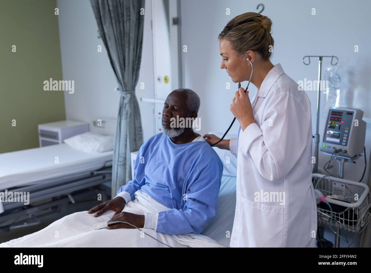 Caucasian female doctor examining with stethoscope african american ...