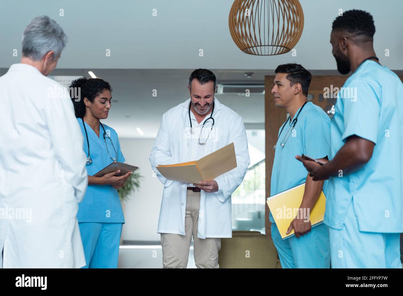 Diverse male and female doctors standing in hospital corridor and ...