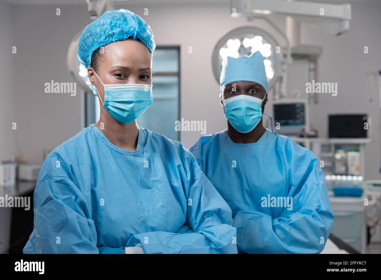 Diverse male and female surgeons wearing face masks and protective ...
