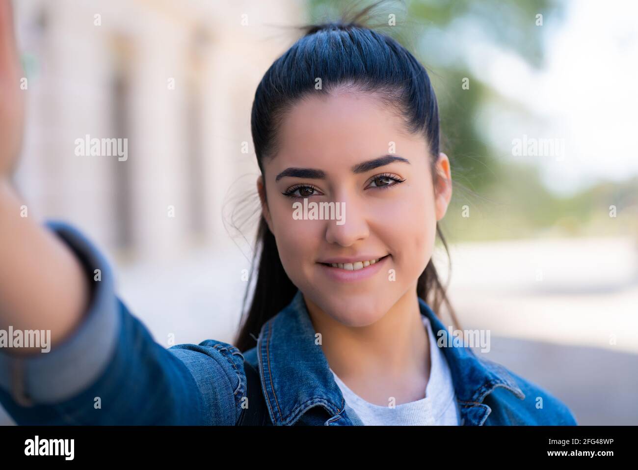Young woman taking selfies outdoors Stock Photo - Alamy