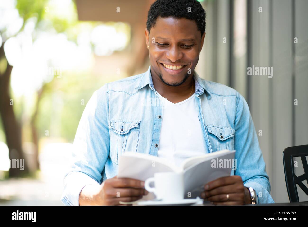 Man reading a book at coffee shop Stock Photo - Alamy
