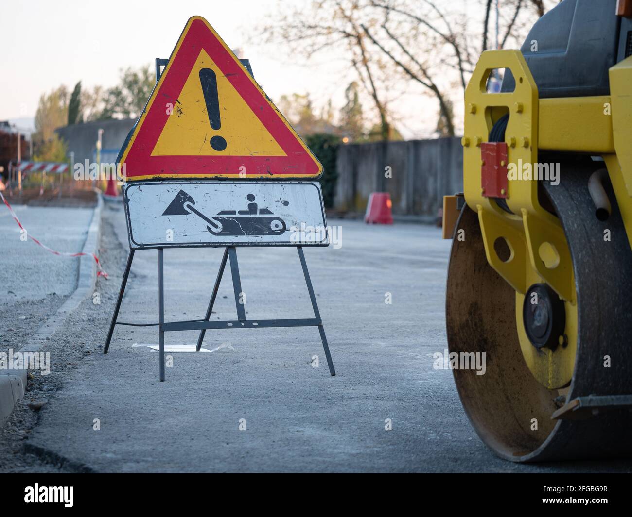 Road Sign showing Work in Progress and Big Machine for Asphalt ...