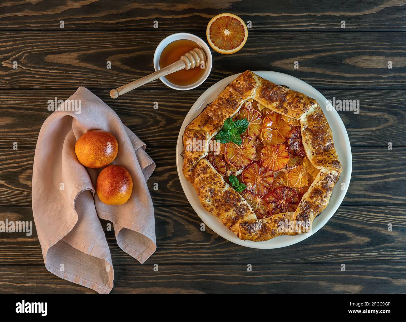 Homemade red blood oranges open pie galette on the plate with mint and ...