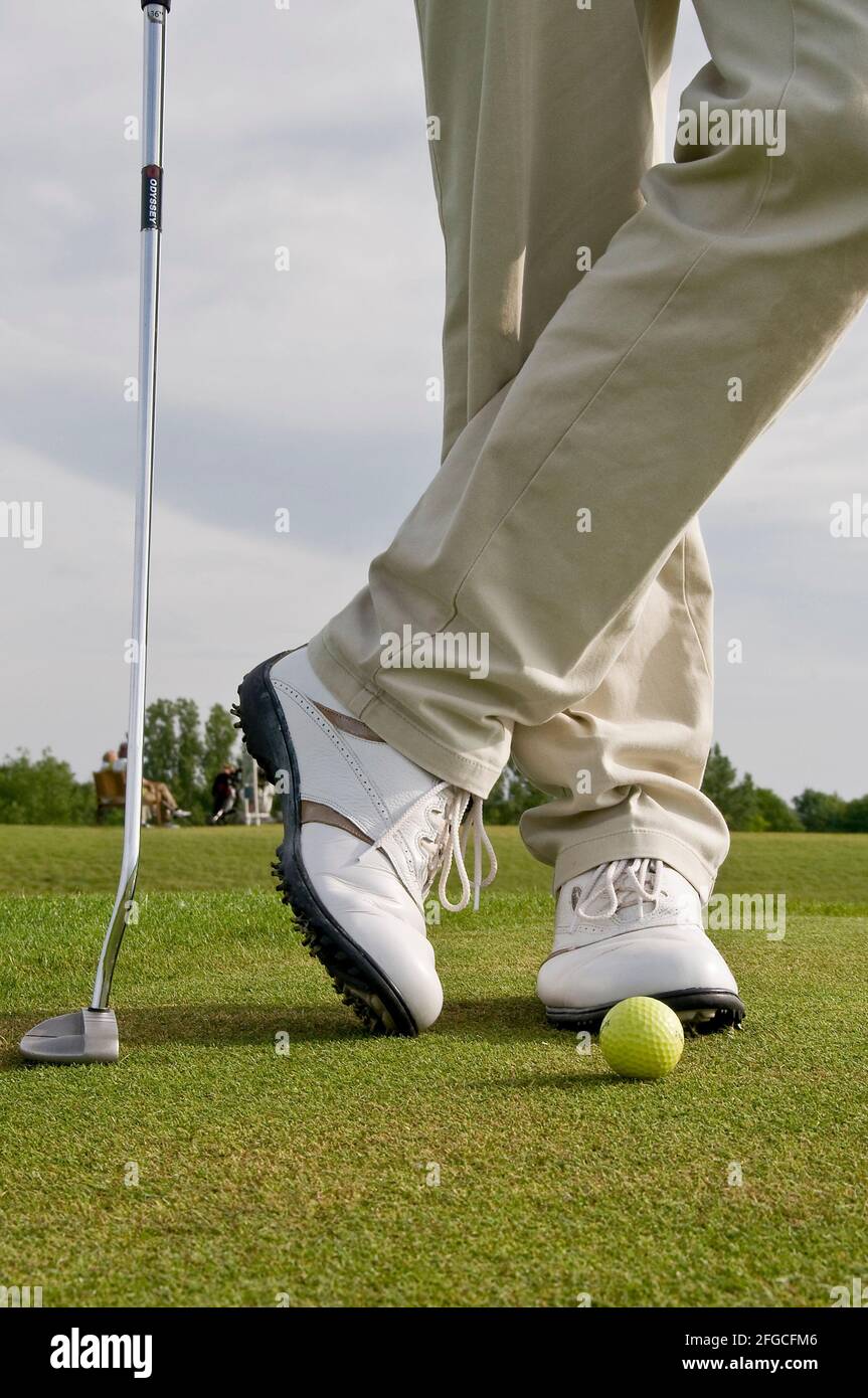 Legs of a golf player with ball and putter on green Stock Photo - Alamy