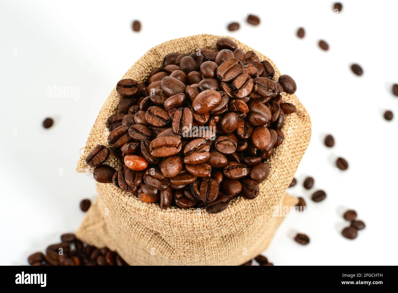 Coffee beans. Jute burlack sack with roasted coffee beans and some dropped beans. Isolated on ...