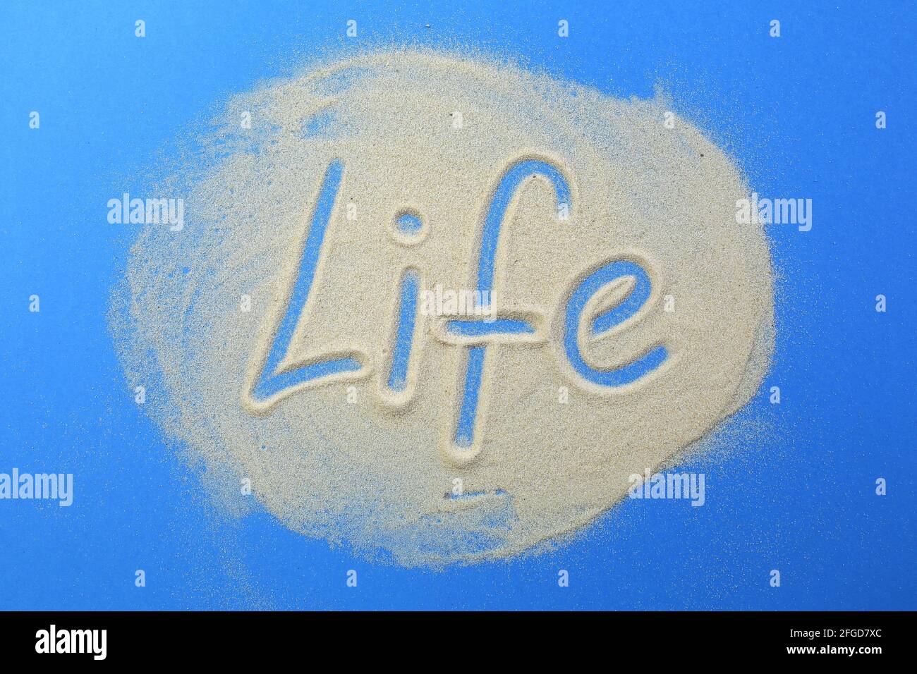 The word life is written in the sand on a blue background Stock Photo ...
