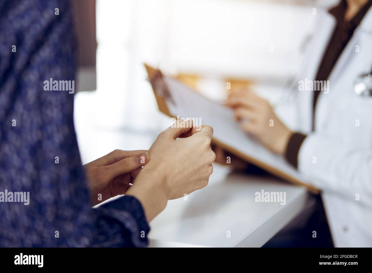 Doctor and patient discussing current health examination while sitting ...