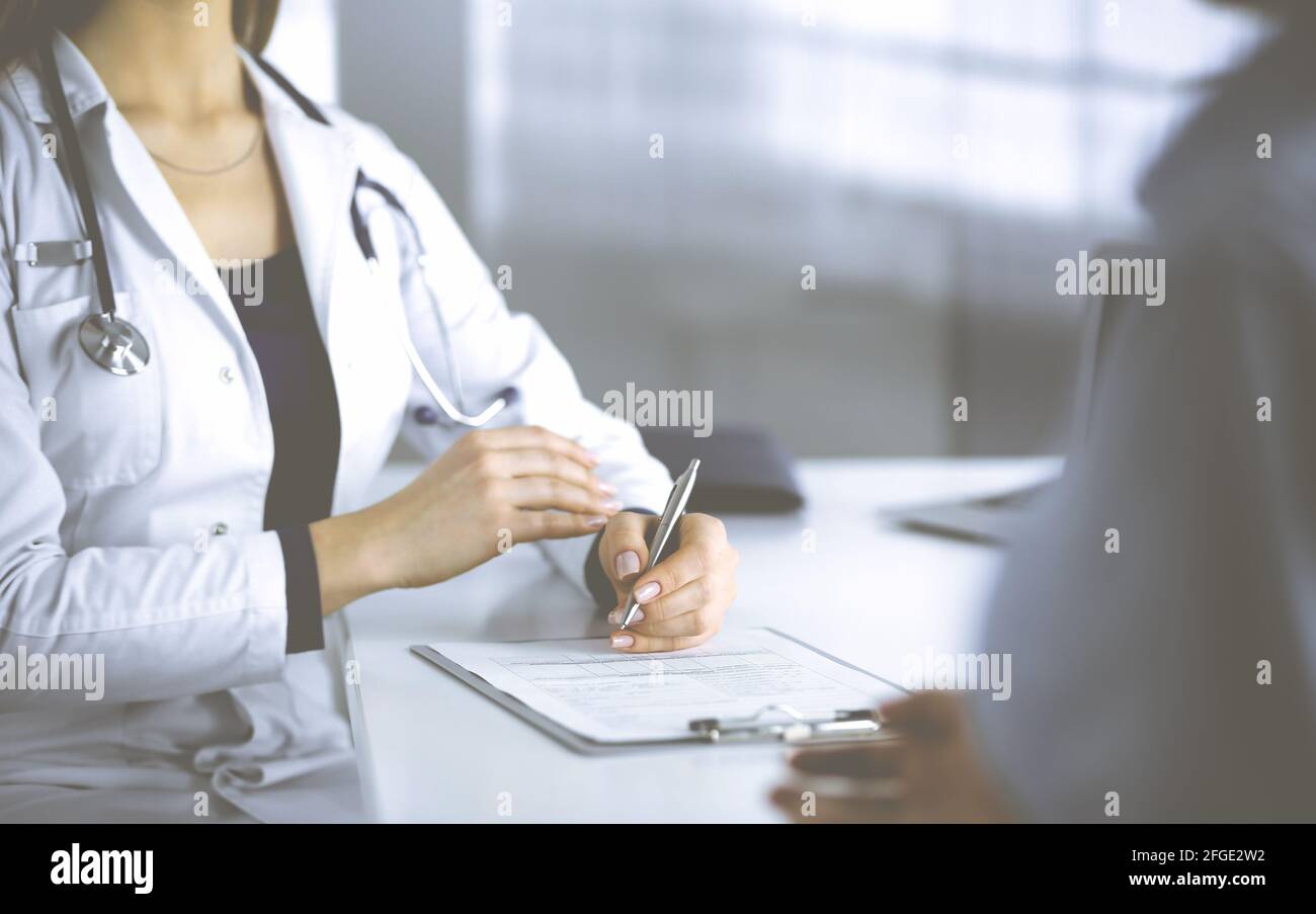 Unknown woman-doctor is prescribing some antibiotics for her patient ...