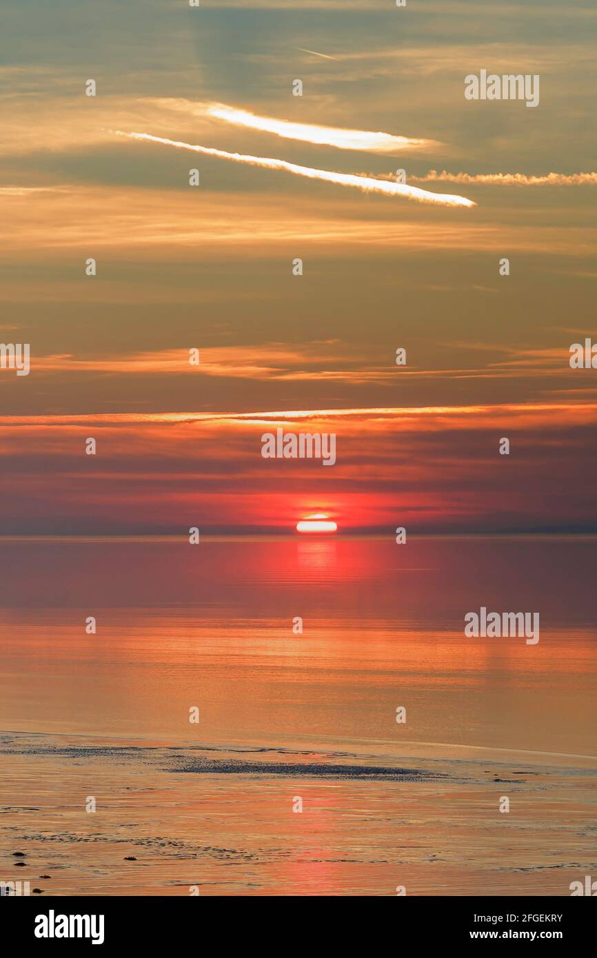 Multiple colours reflecting onto a calm sea Stock Photo - Alamy