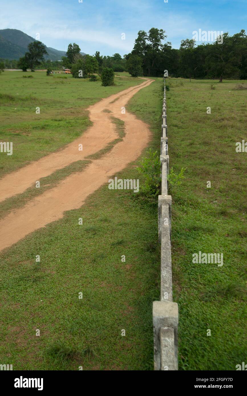 Mountain trail and concrete fence winding through the grass hills with ...