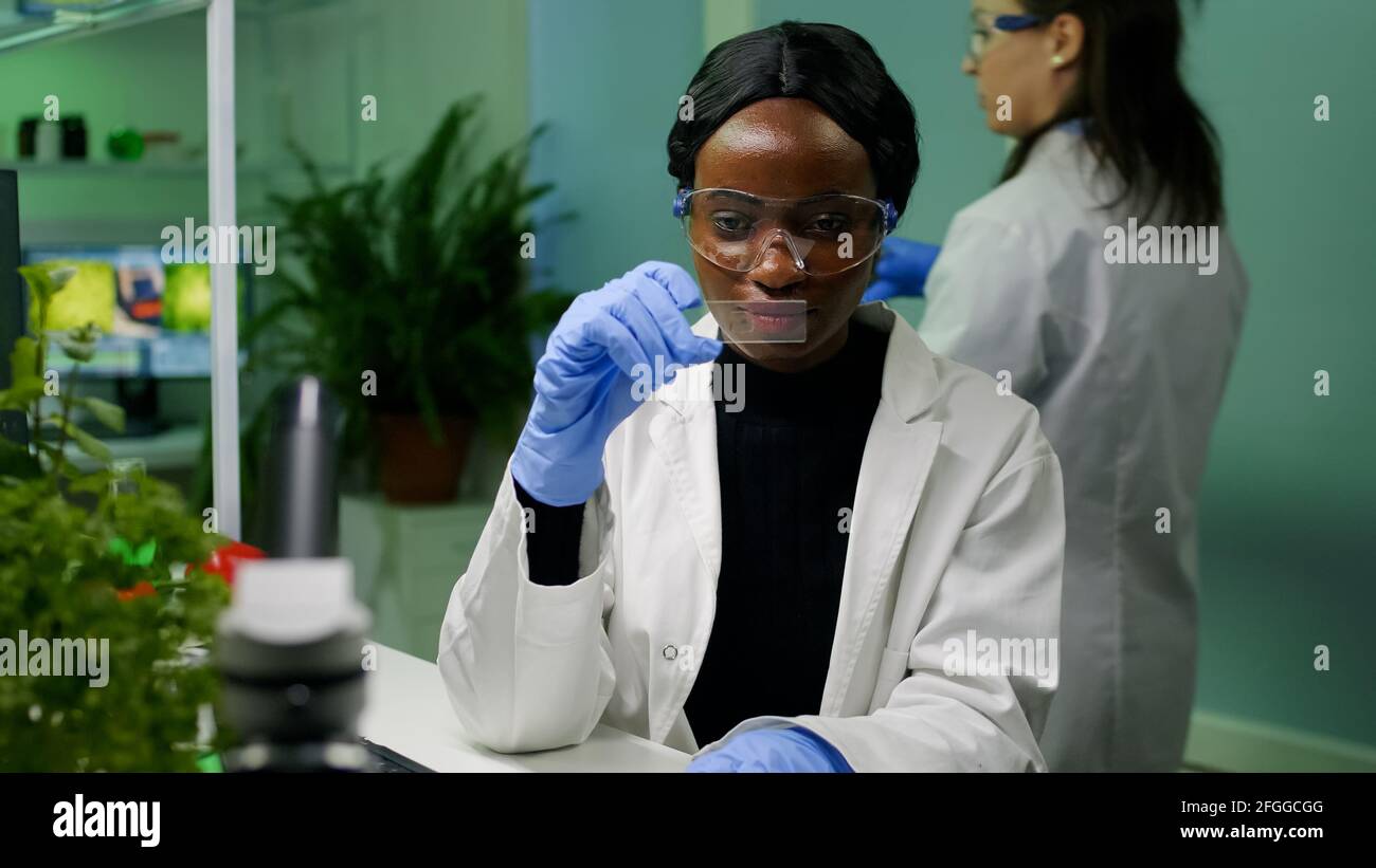 Botanist researcher scientist analyzing green liquid sample under ...