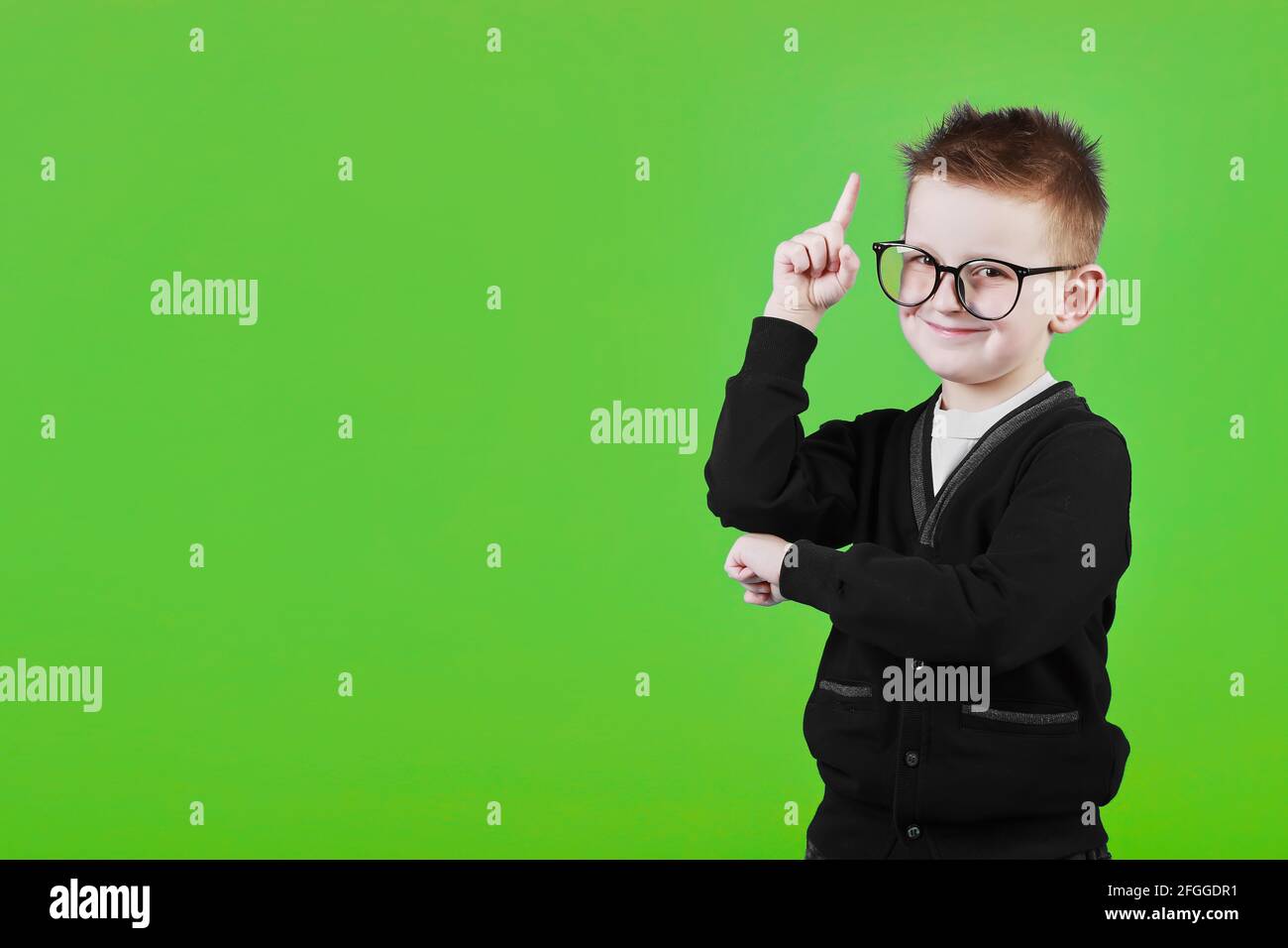 Portrait of stylish little boy with finger pointed up. Little child in ...