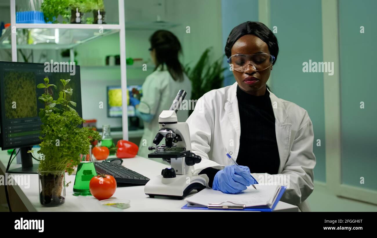 Biologist researcher scientist looking at leaf sample under medical ...
