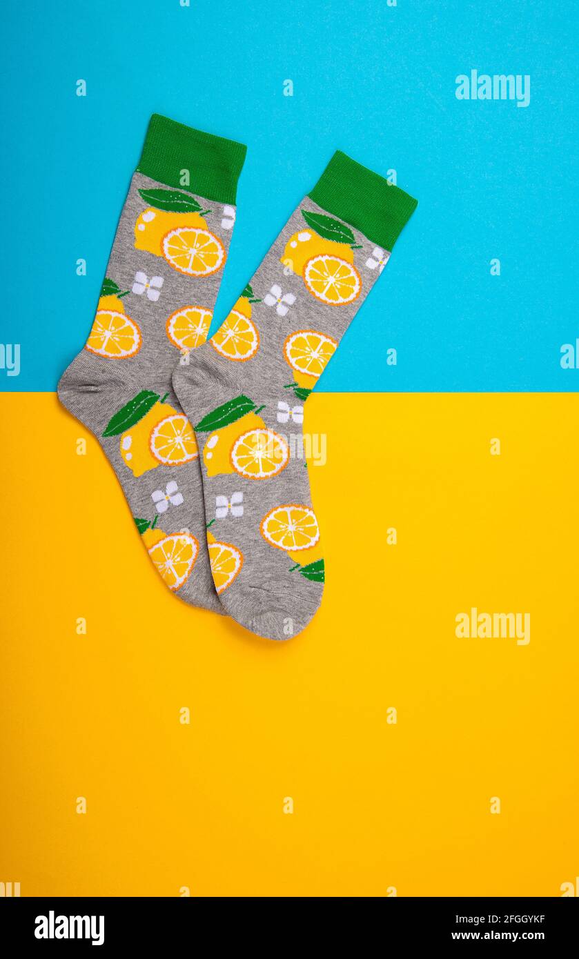 Colorful flat lay with pair of socks isolated on blue and yellow ...