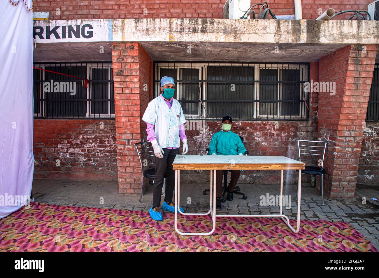 portrait of a medical health worker in face mask wearing scrub during ...