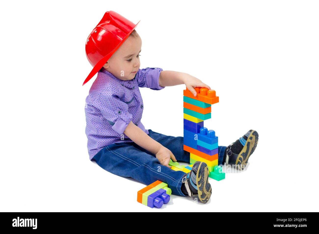 Child plays builder with constructor sitting on floor Stock Photo - Alamy