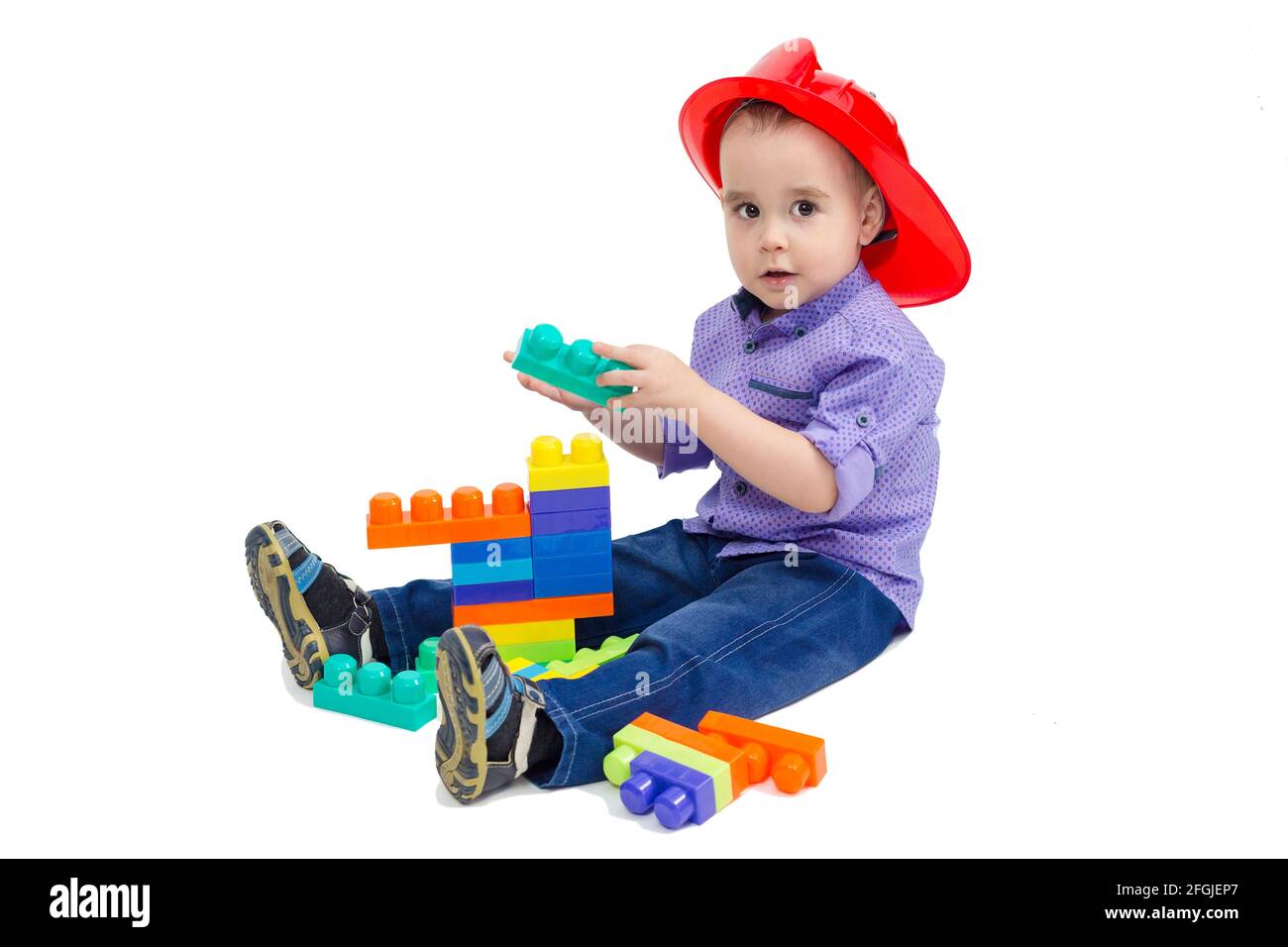 Child plays builder with constructor sitting on the floor Stock Photo ...