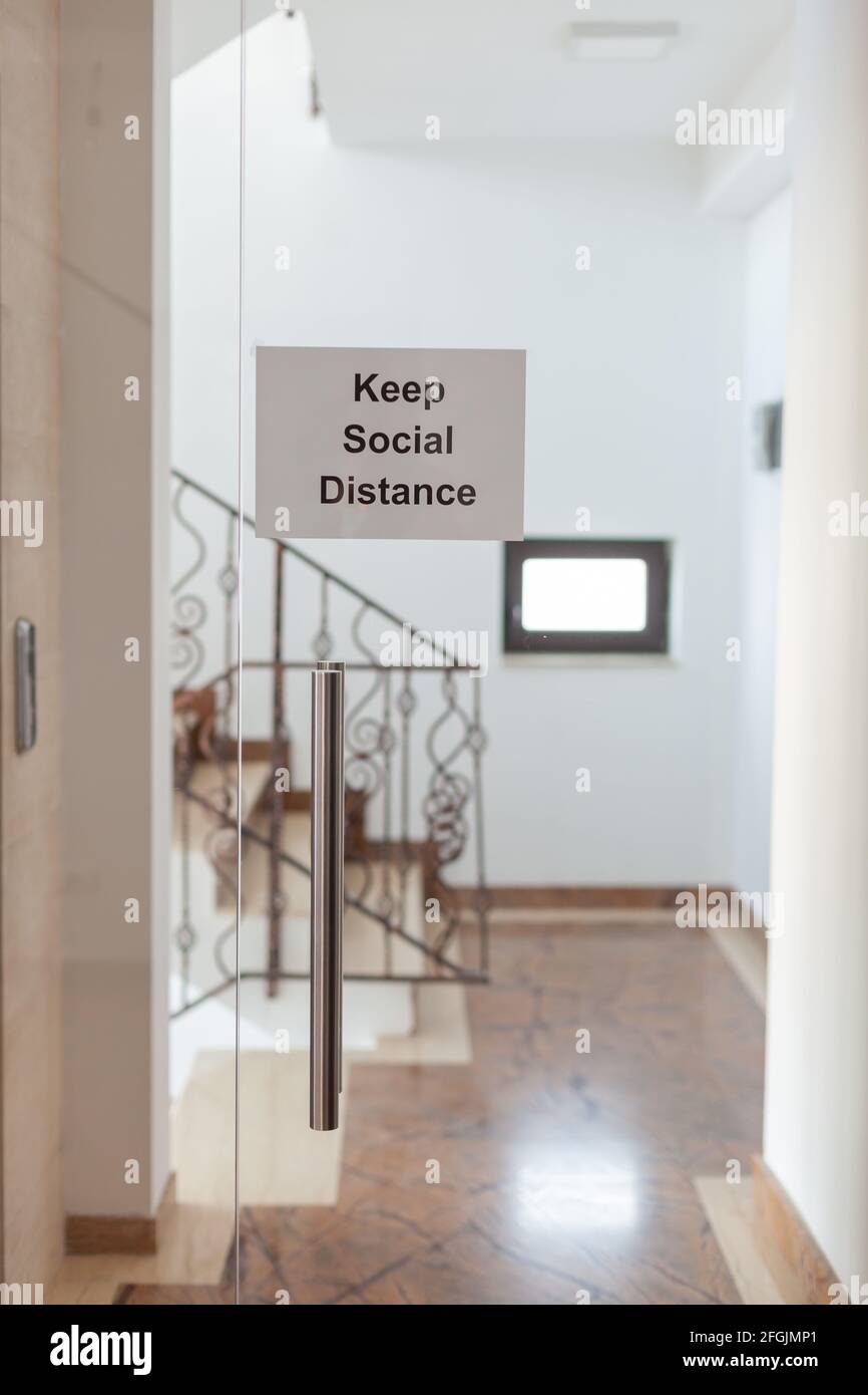 Glass office dor with keep social distance poster on it, modern office ...