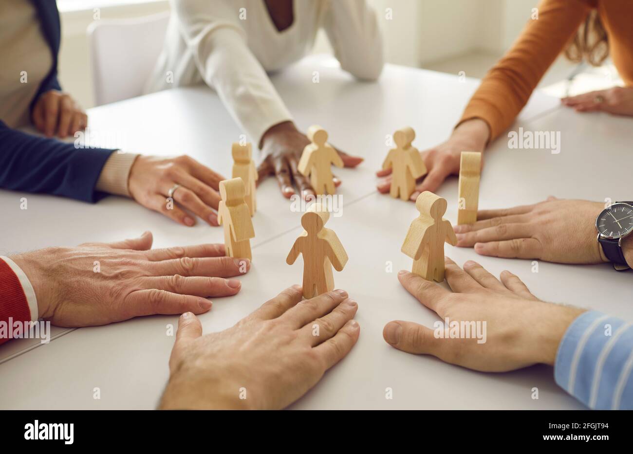 Team of business people put little human figures in circle as symbol of ...