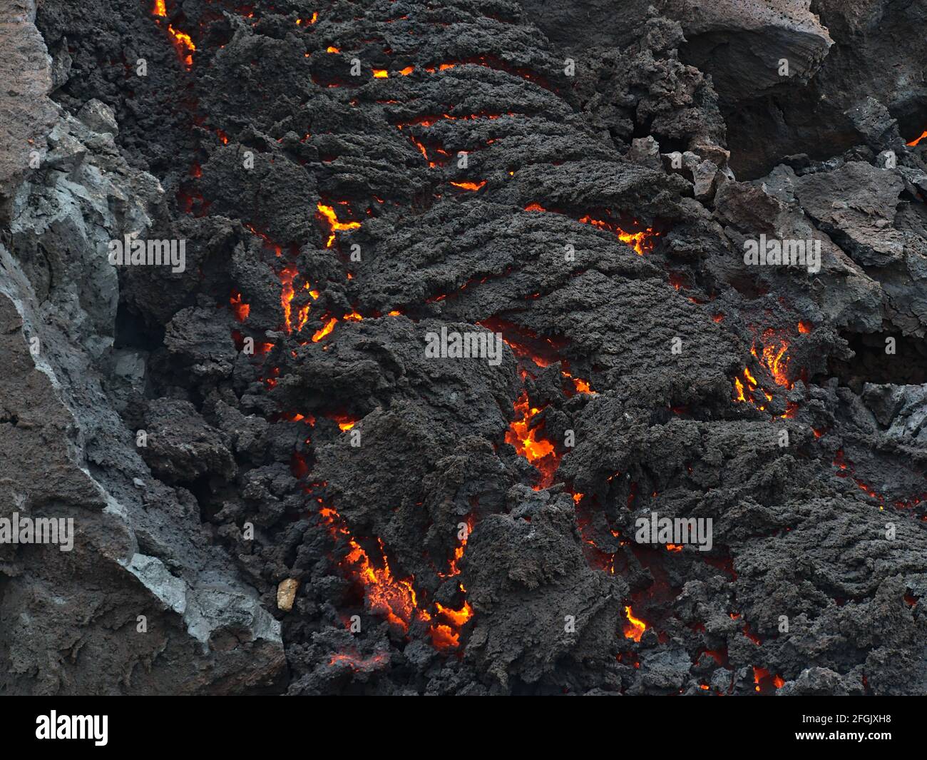 Closeup view of glowing lava rocks cooling down after volcanic eruption ...