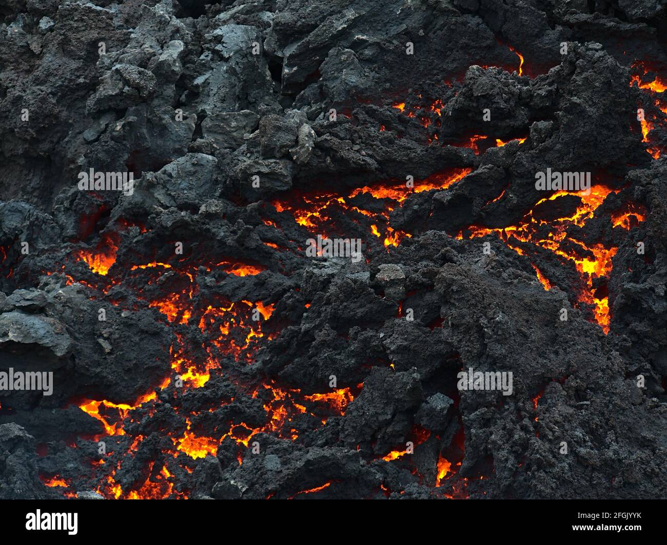 Closeup view of cooling down lava rocks with orange glow after the ...