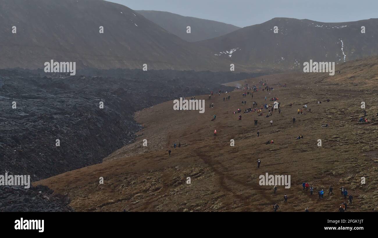 People observing the eruption of a volcano in Geldingadalir valley near ...