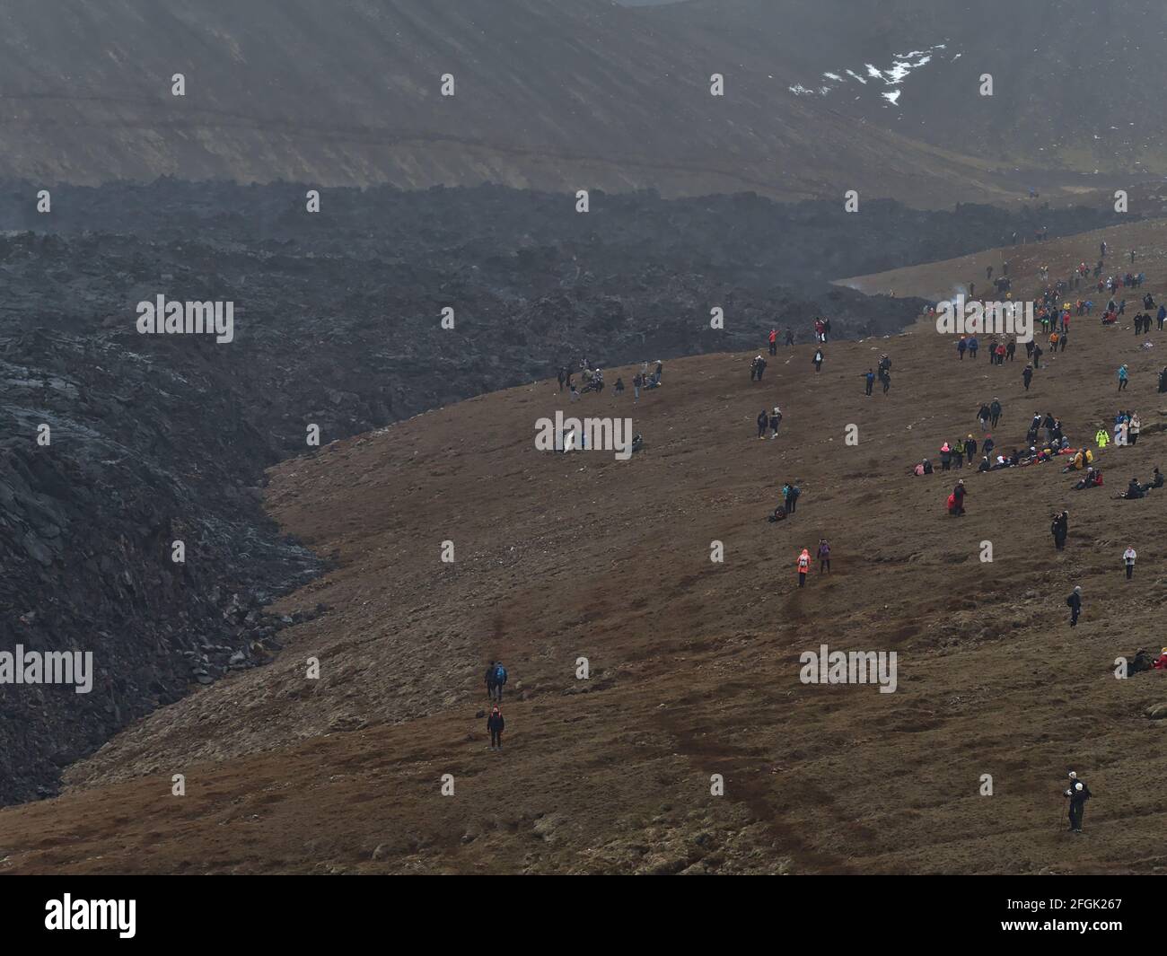 People watching a volcanic eruption in Geldingadalir valley near ...