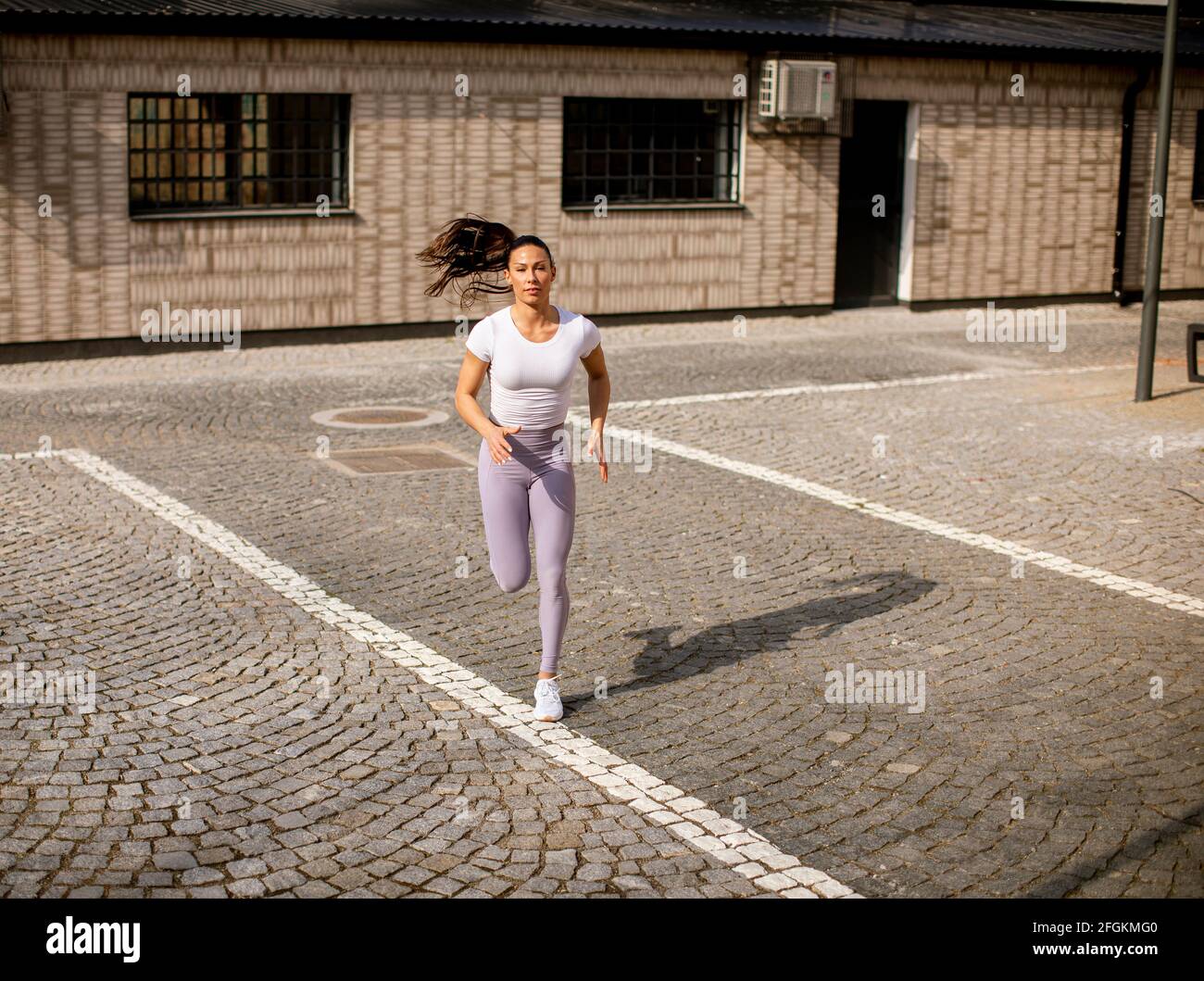 Pretty young woman running on the street Stock Photo - Alamy