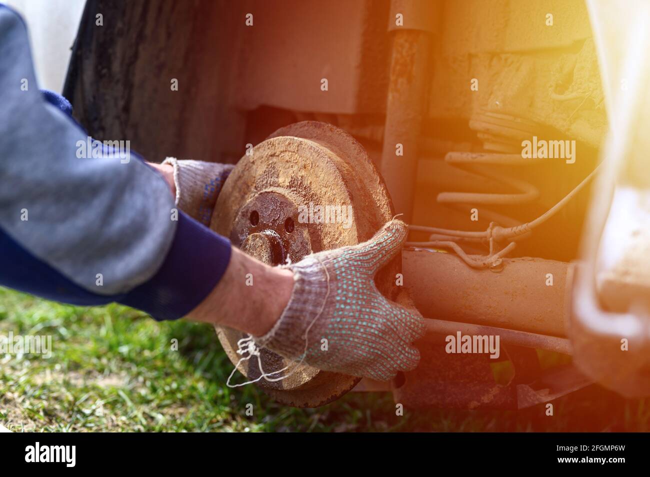 men's gloved hands repair of car drum brake himself. repair of broken ...