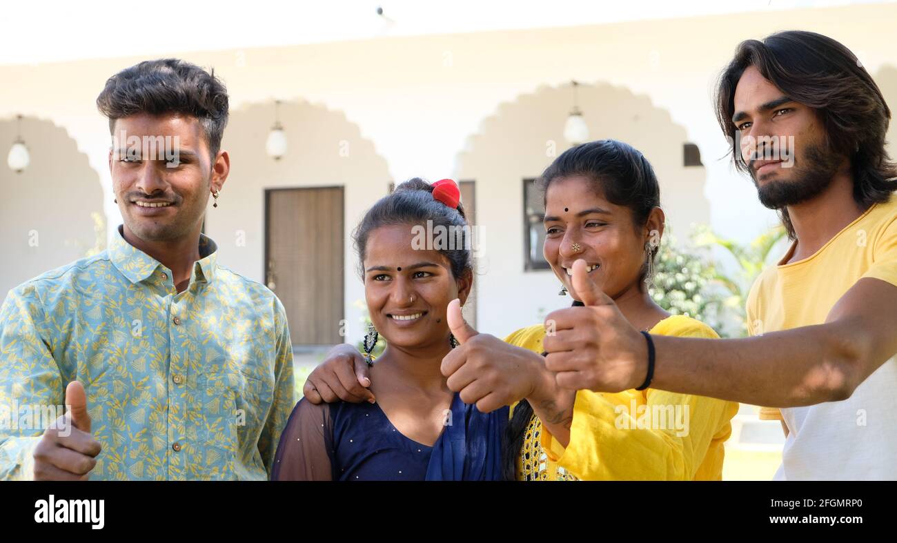 A group of young Indian people with their thumbs up being photographed ...