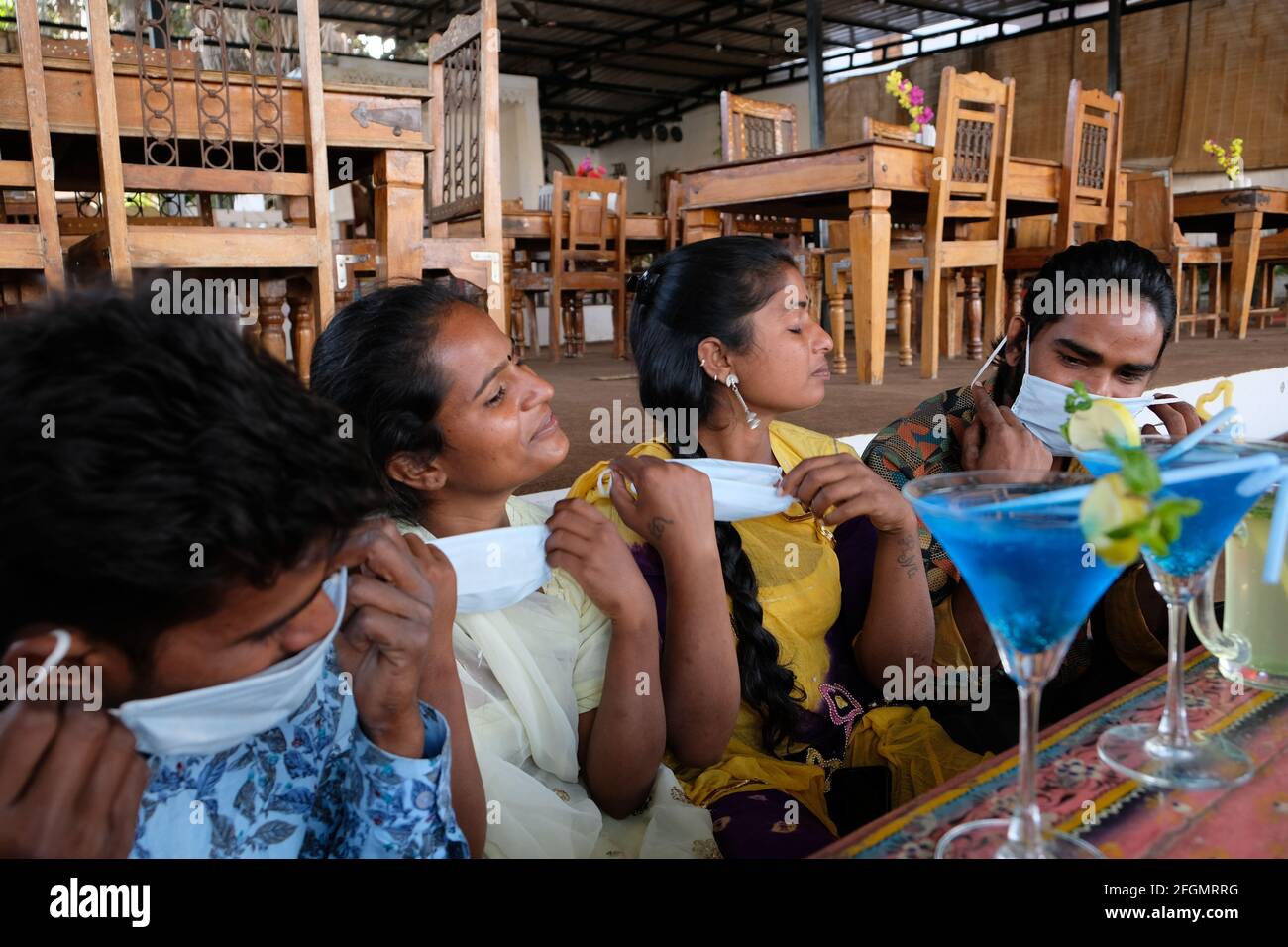 A group of young Indian cheerful people enjoying their time in a cafe ...