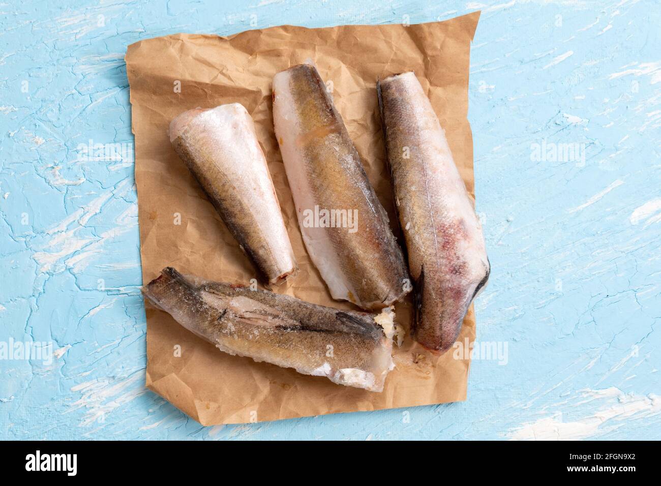 Raw frozen hake fish on a blue background. top view copy space Stock ...
