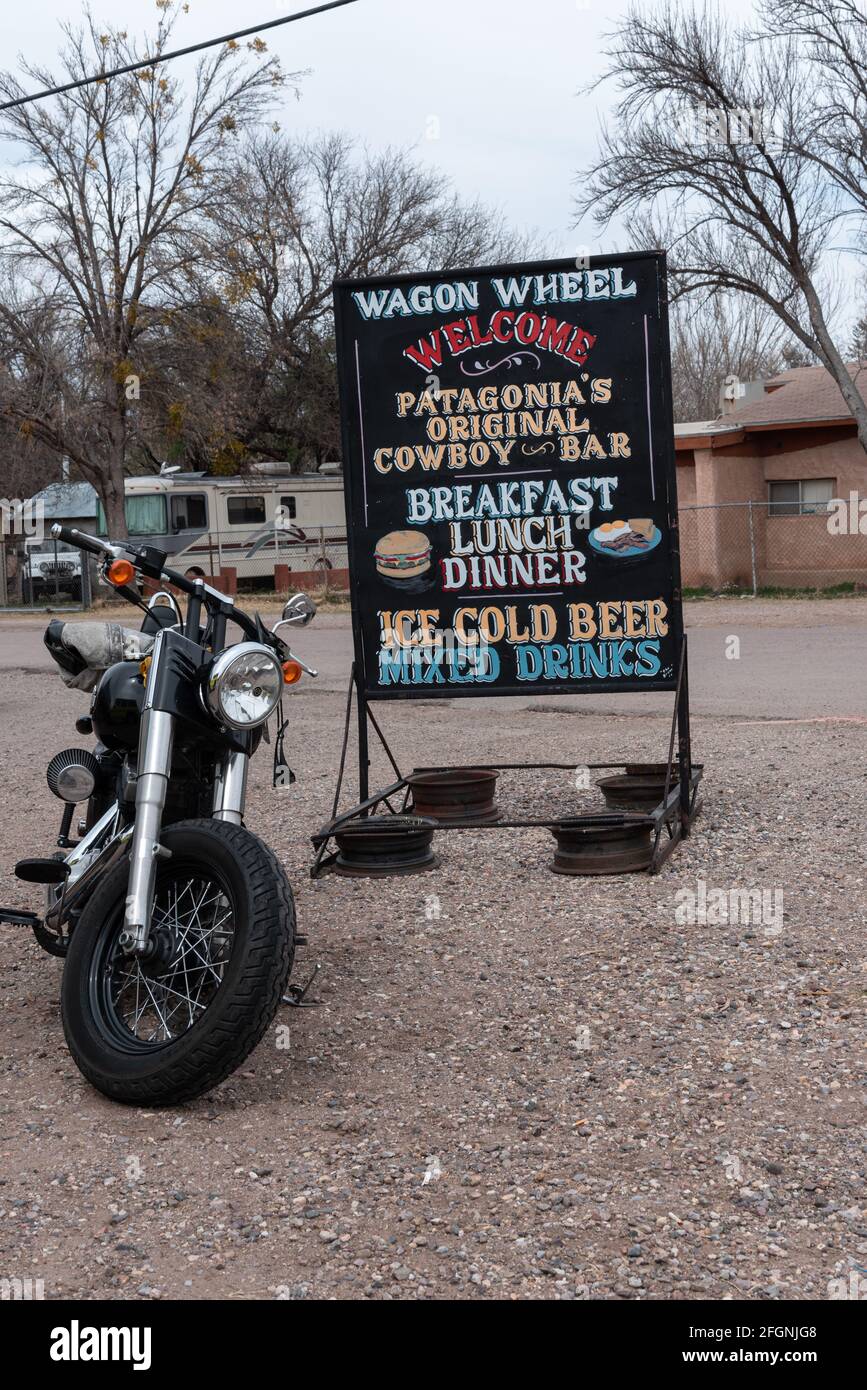A motorcycle parked next to a sign for the Wagon Wheel restaurant ...