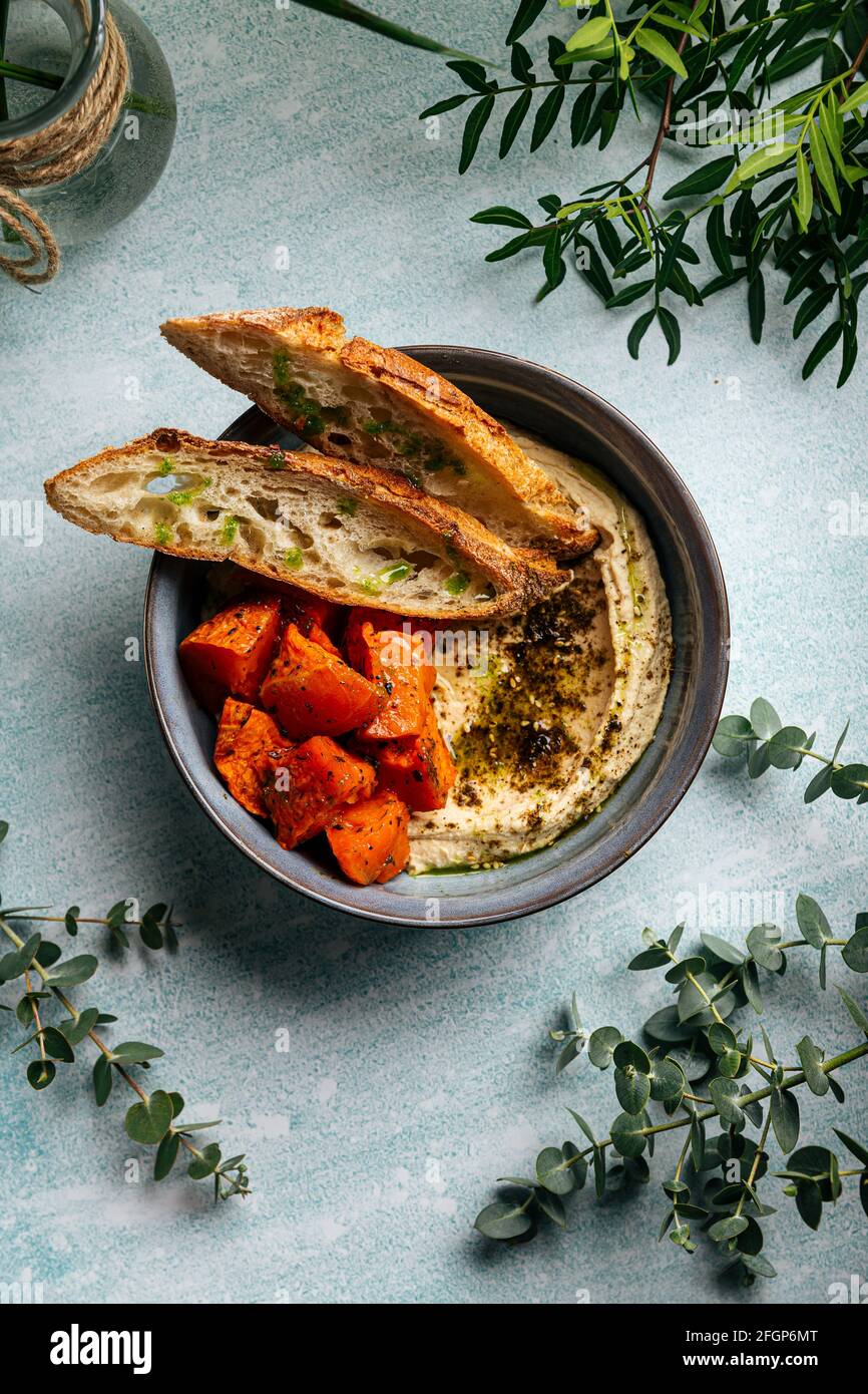 Hummus with honey pumpkin zaatar and crispy bucket Stock Photo - Alamy