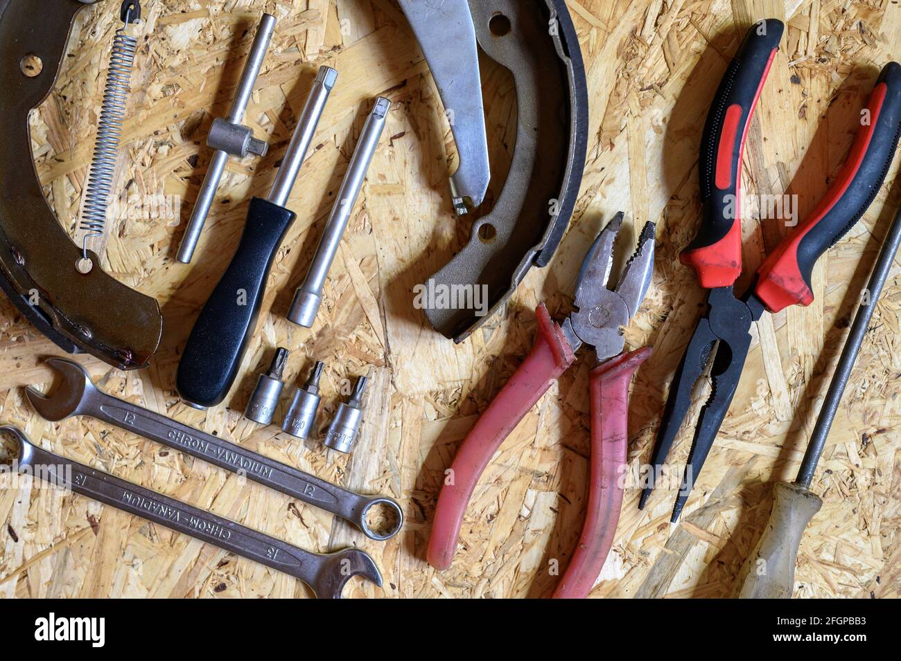 car drum brake disassembled and a set of various repair hand tools or ...