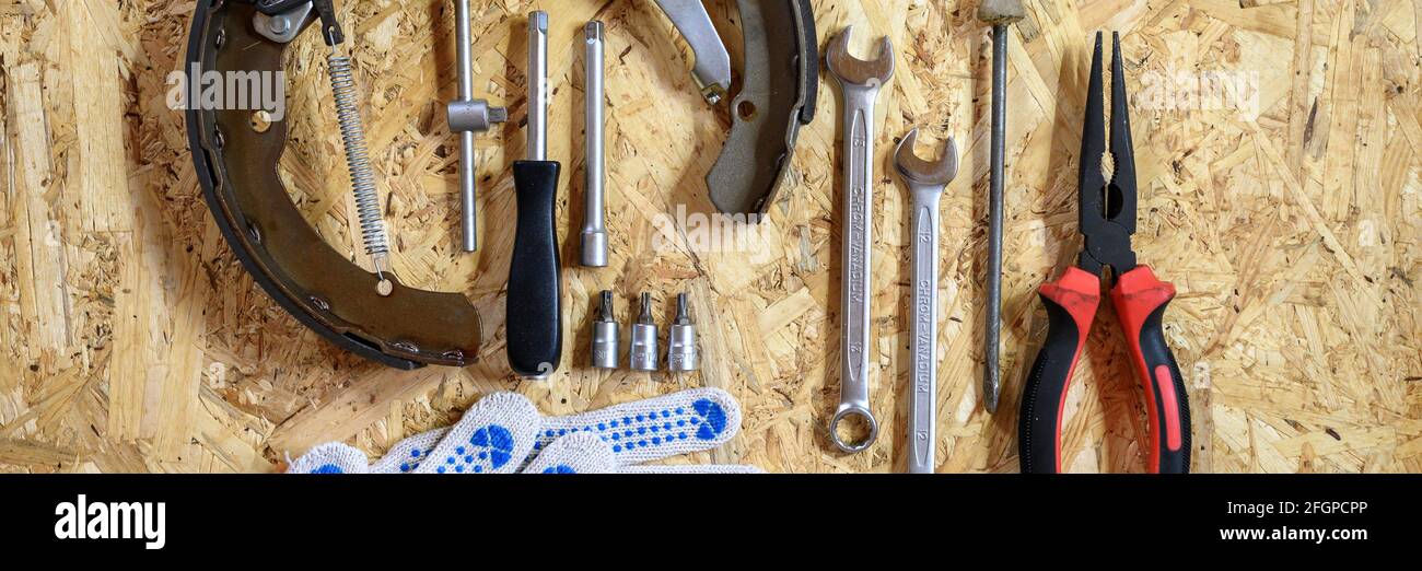 car drum brake disassembled and a set of various repair hand tools or ...