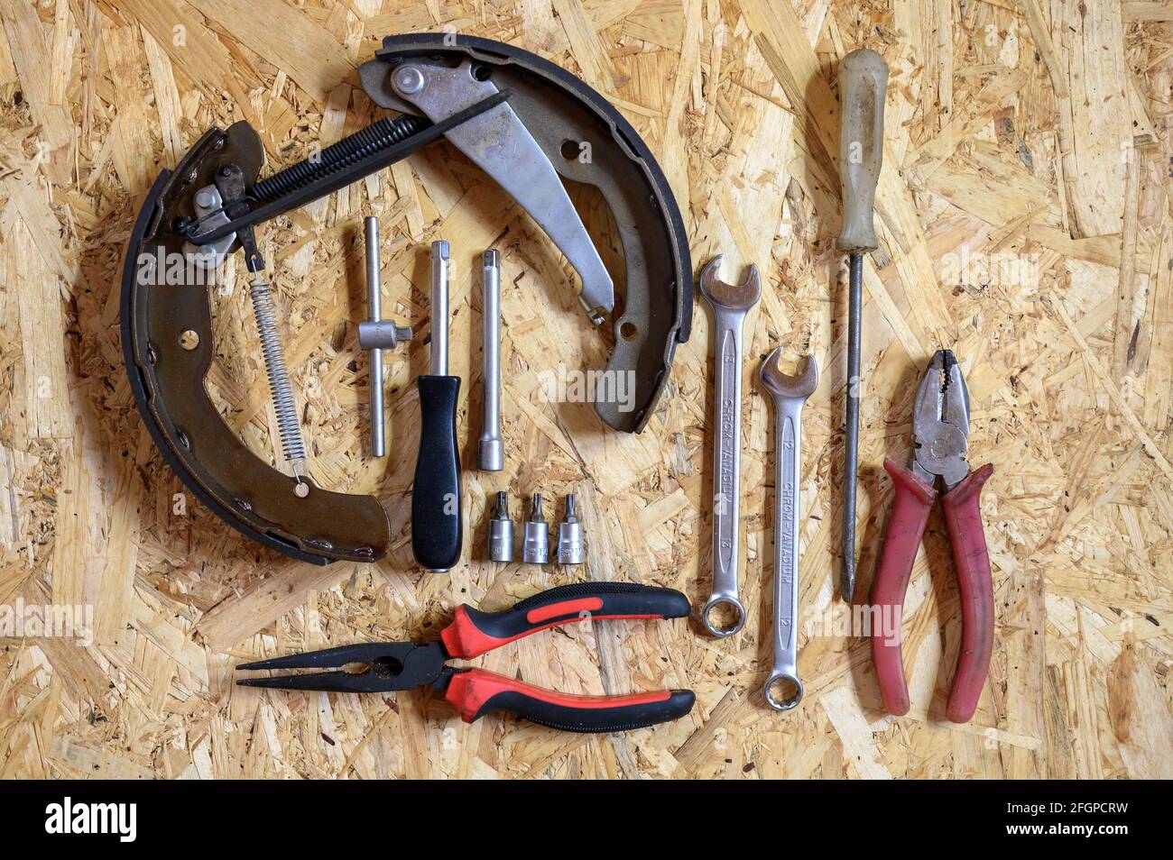 car drum brake disassembled and a set of various repair hand tools or ...