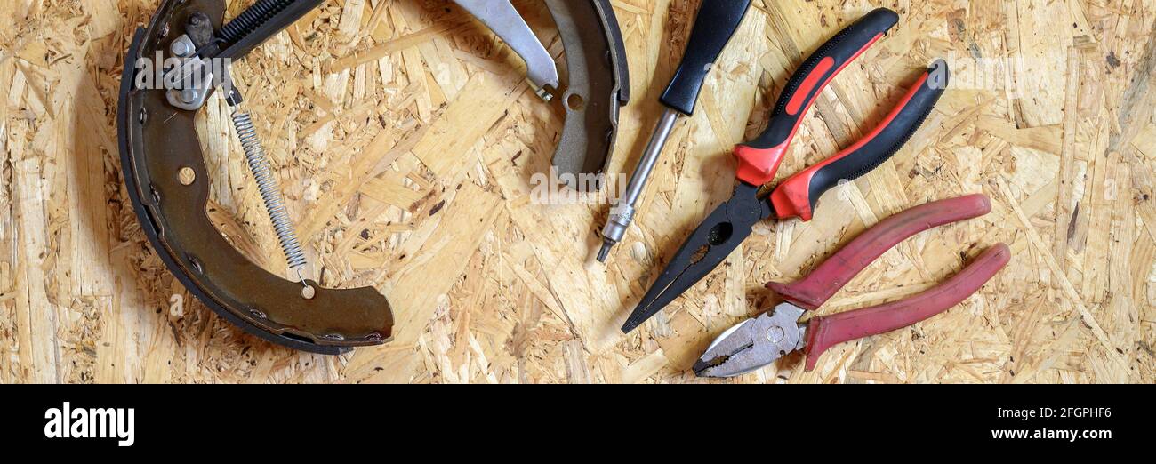 car drum brake disassembled and a set of various repair hand tools or ...