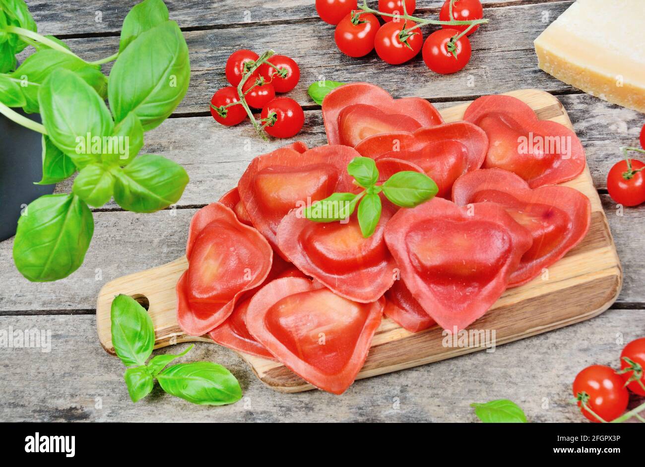Red heart ravioli with tomato, mozzarella and basil on a vintage table ...