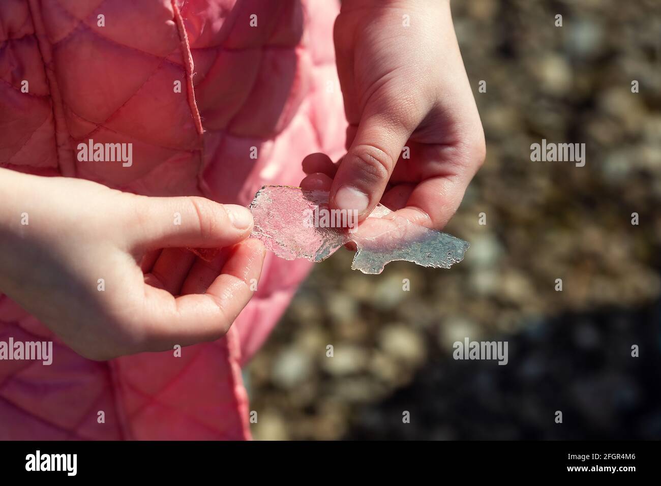 Children hands holding a piece of transparent ice Stock Photo - Alamy