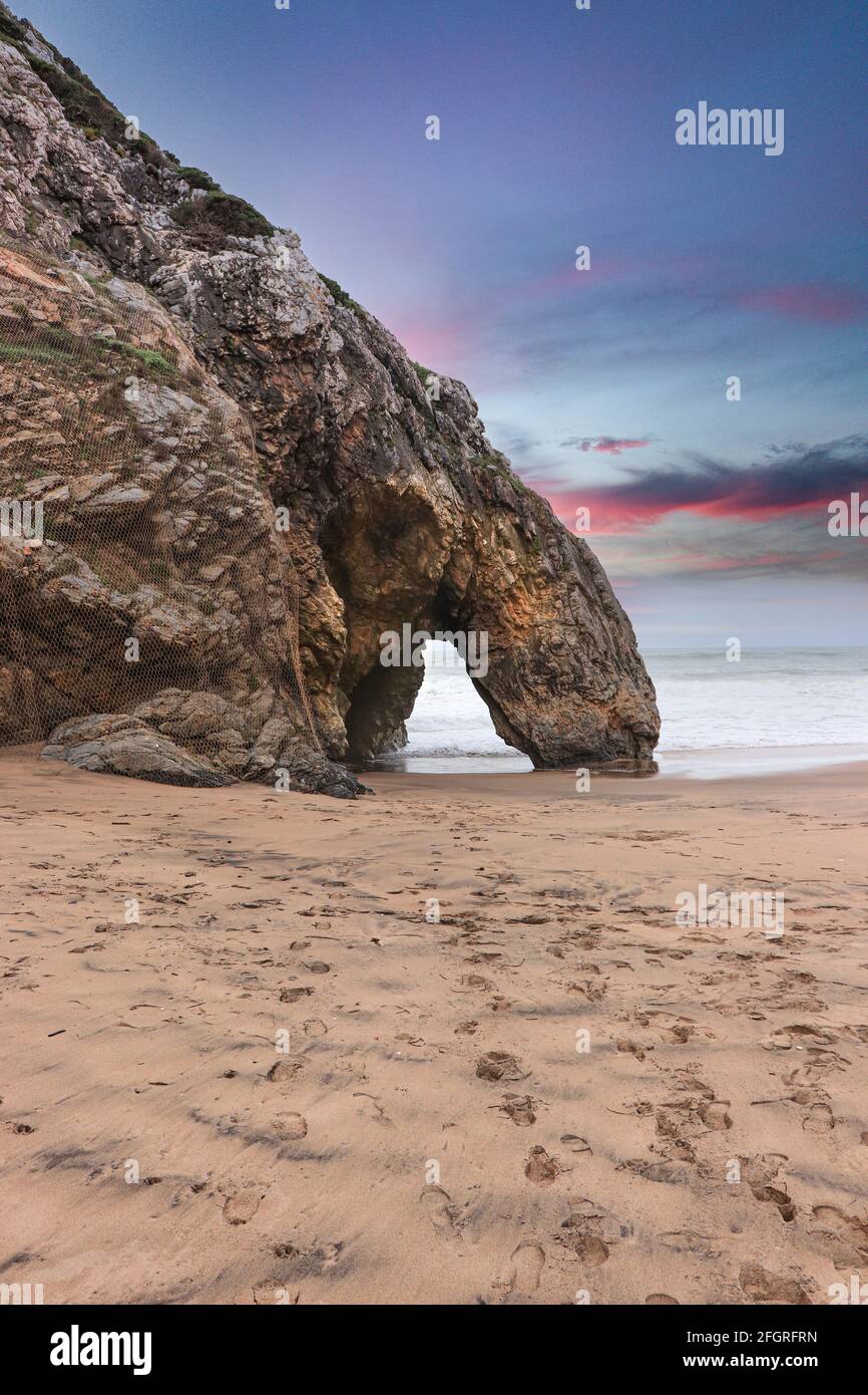 Beautiful stone natural arche at the sunset. Rock formation in a beach ...