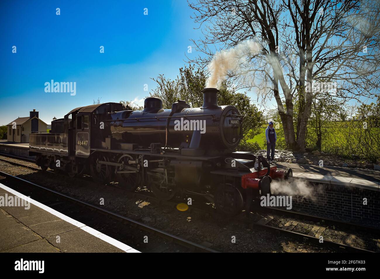 A Man Stands Beside A Steam Locomotive As He Has His Photograph Taken