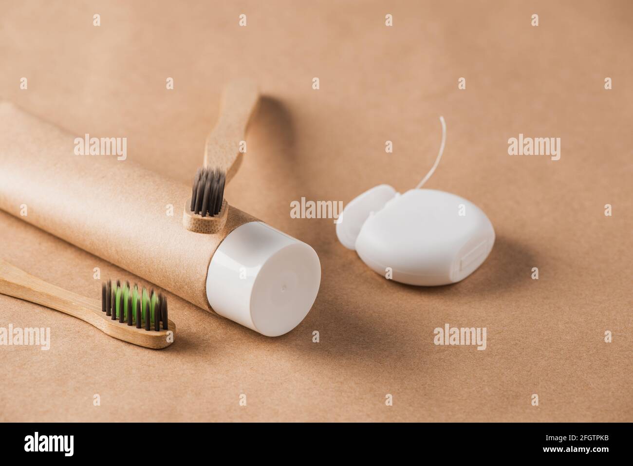 Close-up on set of two wooden toothbrushes, toothpaste and dental floss ...