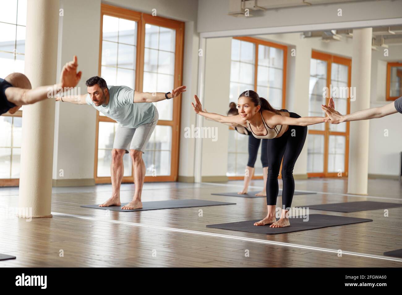 Group of young sporty people practicing yoga lesson with instructor ...