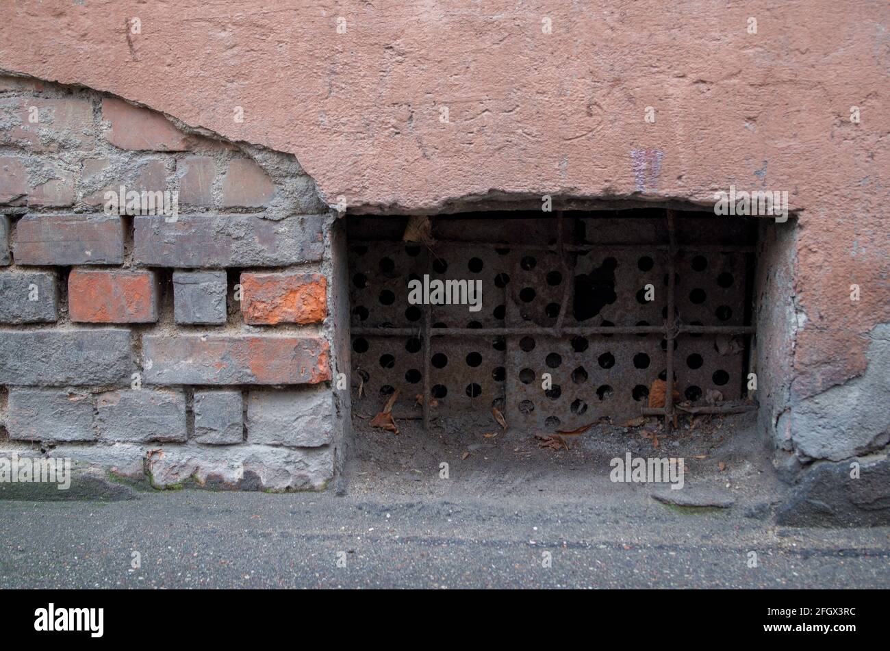 Hollow-window leading to basement sealed with rusty metal perforated ...