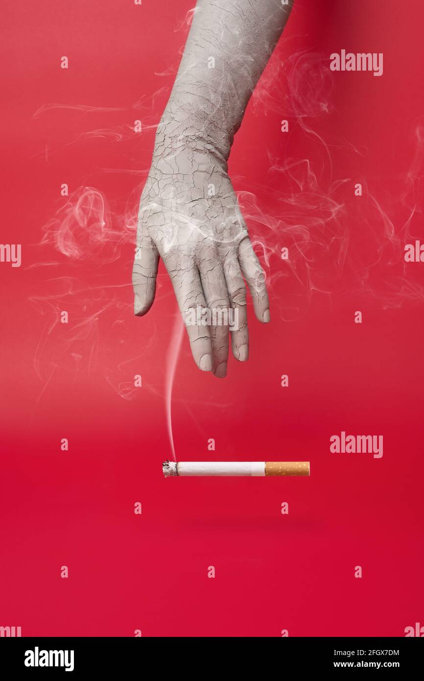 Dry and cracked hand and a smoking cigarette on red background Stock ...