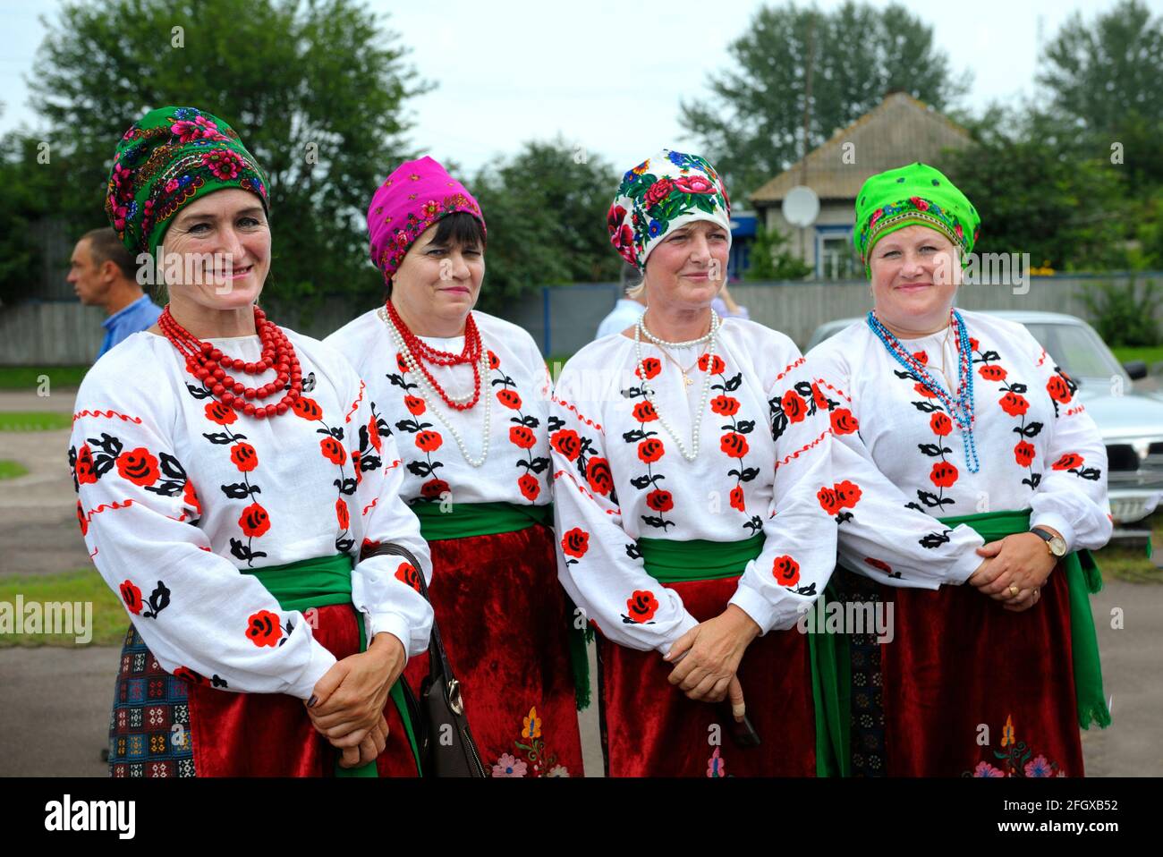 Middle aged women in Ukrainian native dresses standing on a rural ...