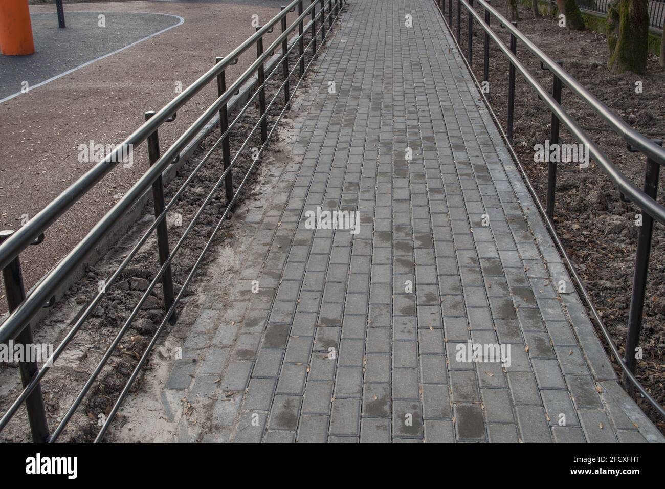 Stretching into perspective gray sidewalk with rectangular tiles and a ...